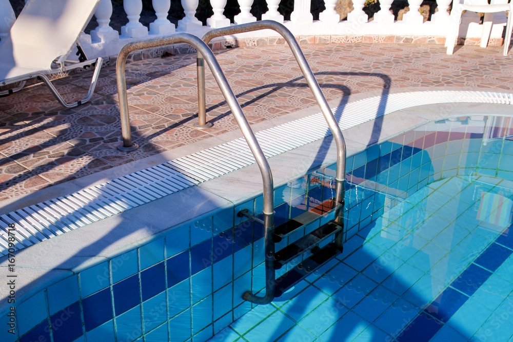 Handrail on the pool. Swimming pool with stair closeup. Pool handrails ...