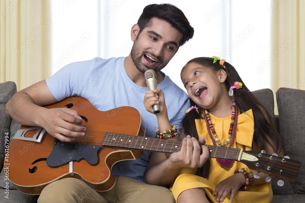 Father and daughter singing while playing guitar Stock Photo | Adobe Stock