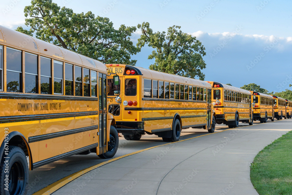 school bus line in parking lot of high school Stock Photo | Adobe Stock
