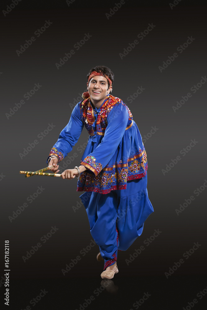 Full length portrait of Indian man in traditional wear performing ...
