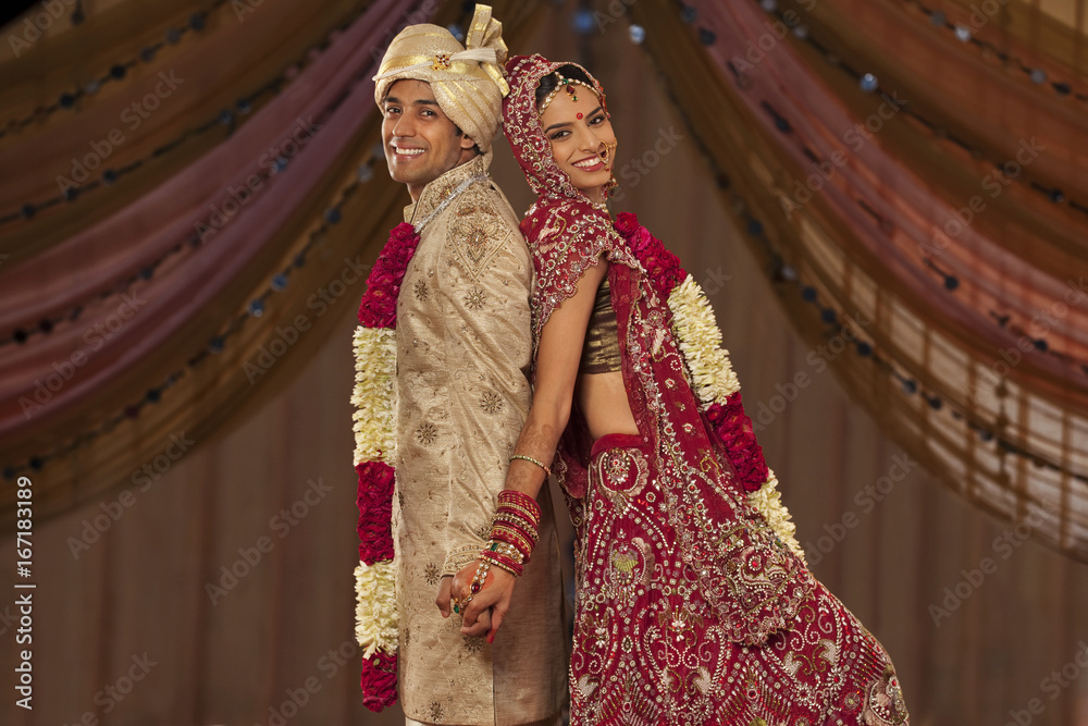 Portrait of newly married Indian couple holding hands Stock Photo ...