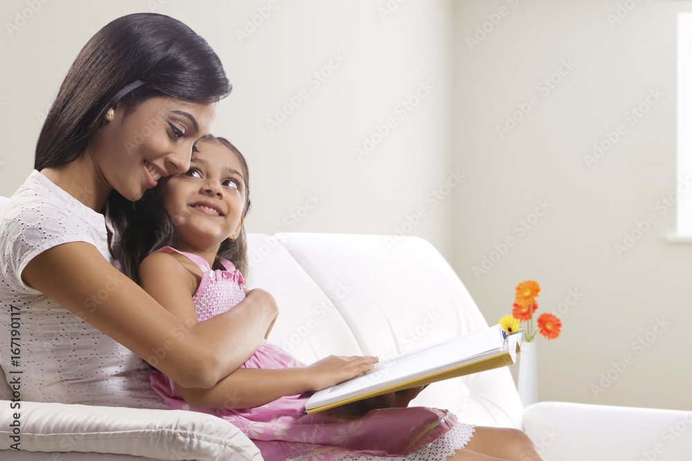 Mother and daughter with a story book Stock Photo | Adobe Stock