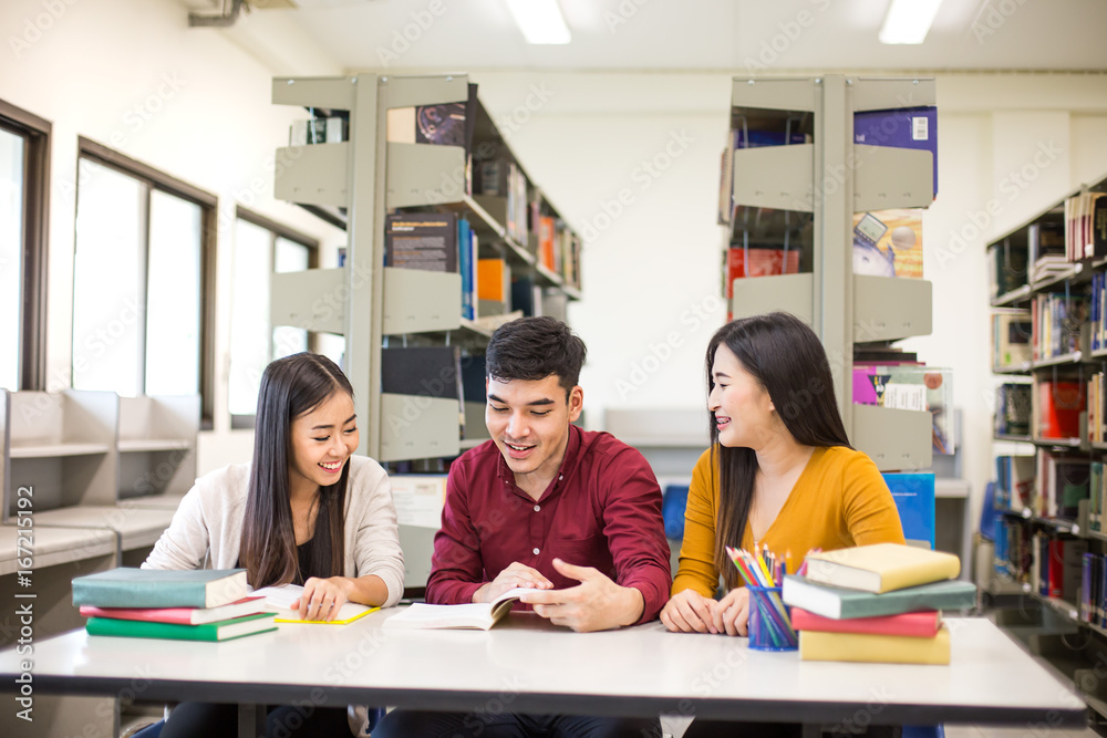 Group of Student reading books in the library with attractive smiling ...
