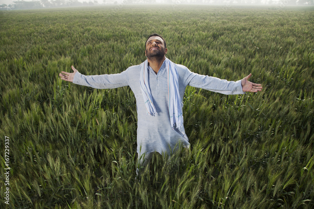 Indian man standing in field with arms out Stock Photo | Adobe Stock