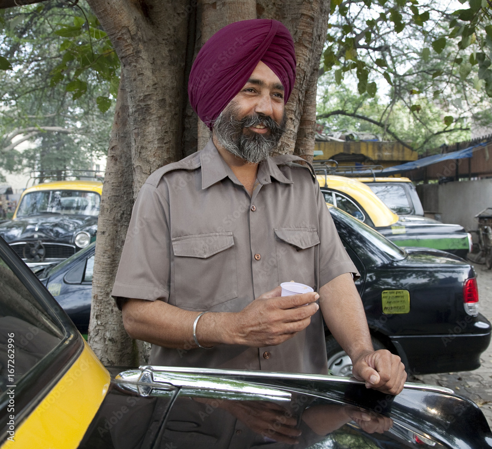 Sikh man standing next to his taxi Stock Photo | Adobe Stock