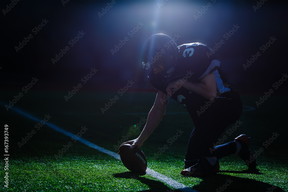 Football player with a black uniform on his knees on a stadium Stock ...