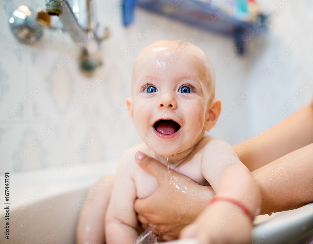 Happy laughing baby taking a bath. Little child in a bathtub. Smiling ...