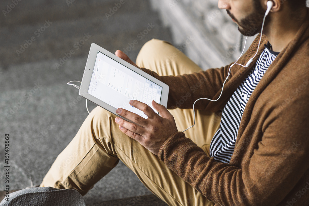 Student Listening to Music on his Tablet Stock Photo | Adobe Stock