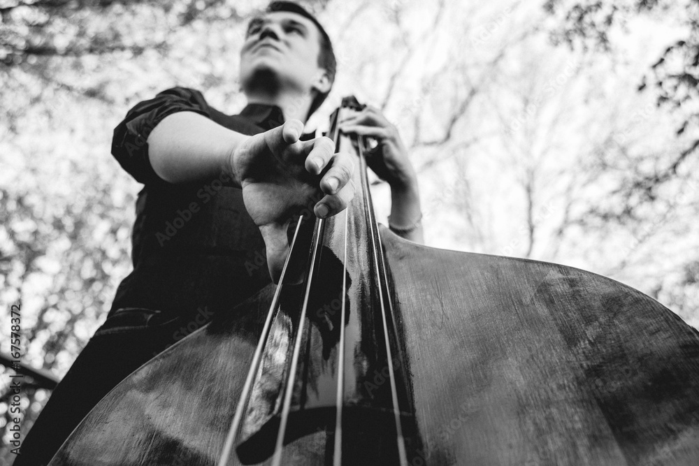 View of musician playing contrabass at the street. Musical Instrument ...
