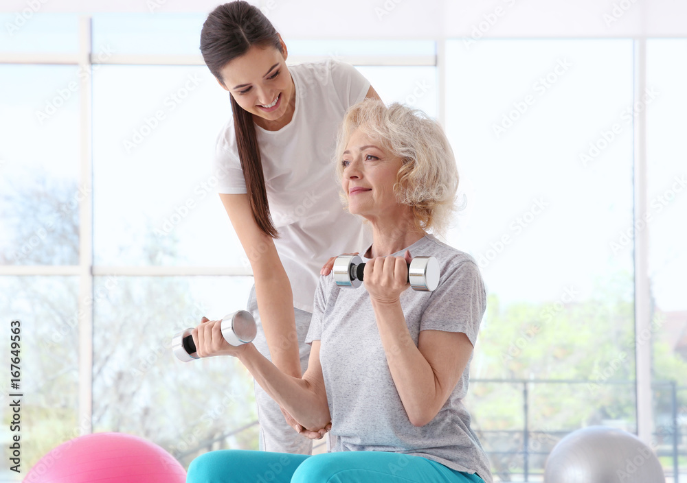 Physiotherapist working with elderly patient in modern clinic Stock ...