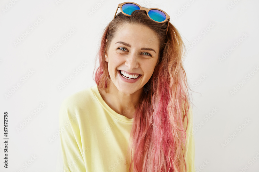 Headshot of attractive young female with pink hair tips, wearing yellow ...