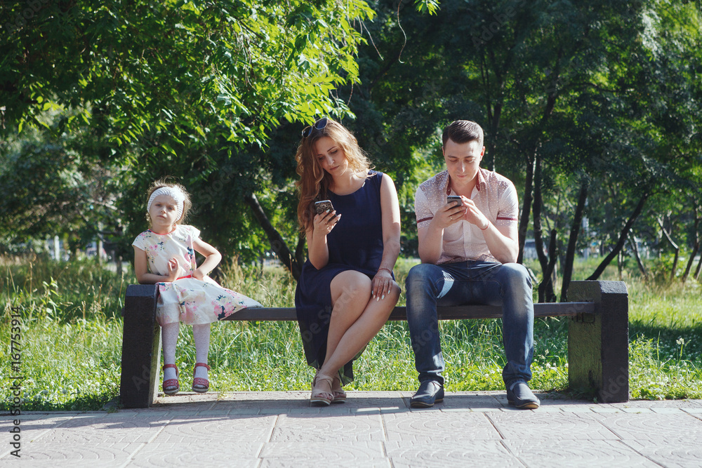 Young parents ignoring each other and the child, using their ...