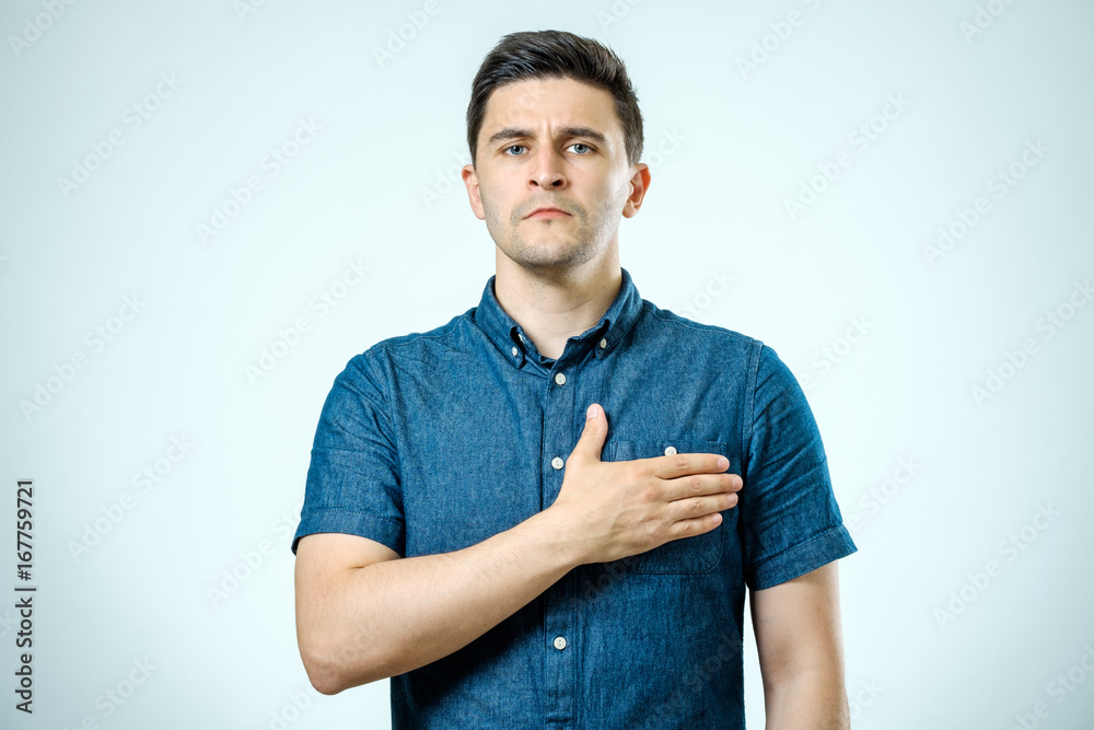 Young guy with his hand on his chest isolated Stock Photo | Adobe Stock