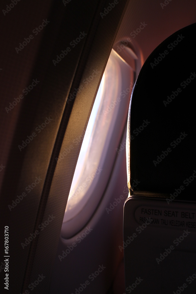 Black aircraft window and backside of the passenger seat with black ...