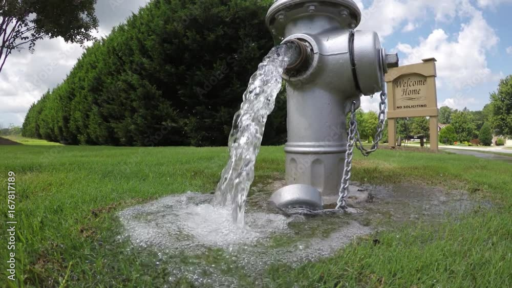 Opened silver fire hydrant with heavy flow clear water coming out ...