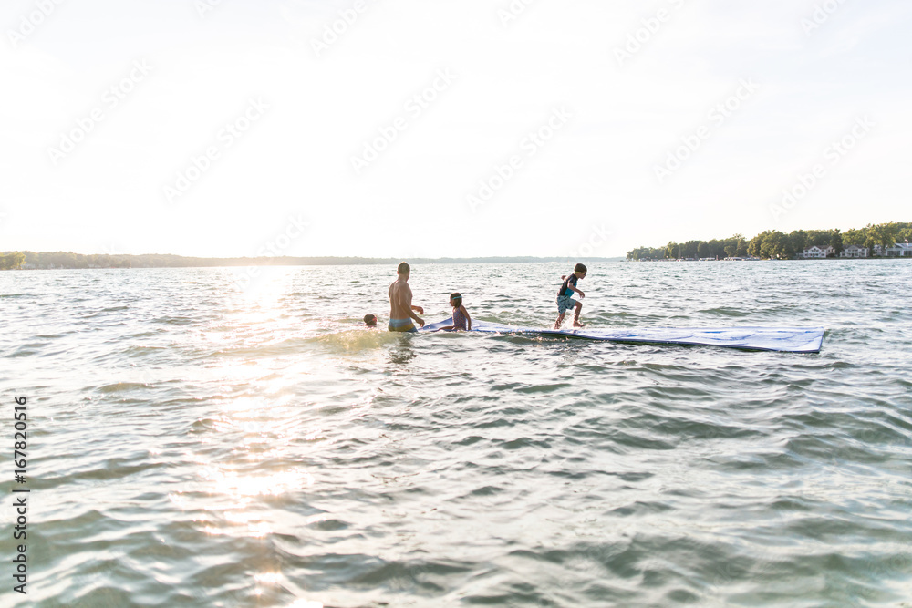 Small group of people playing in lake Stock Photo | Adobe Stock