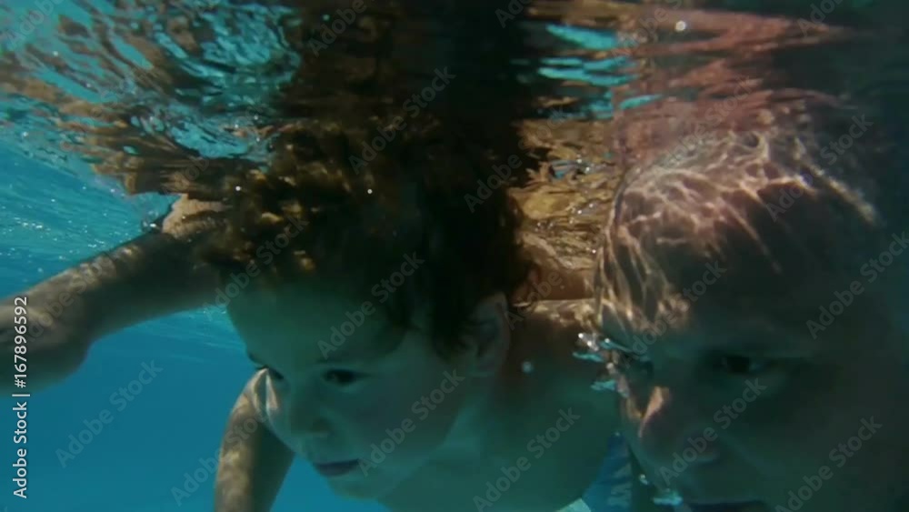 Boy and father diving in swimming pool. Slow Motion. Perfect for videos ...