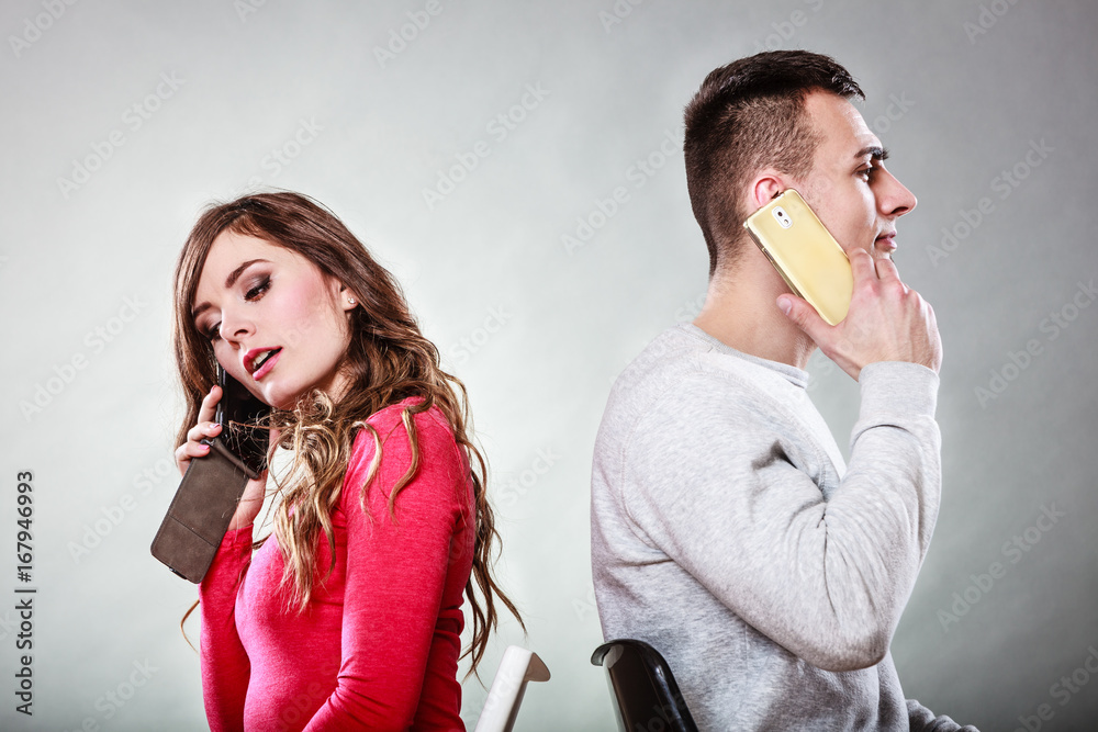 Young couple talking on mobile phones. Stock Photo | Adobe Stock
