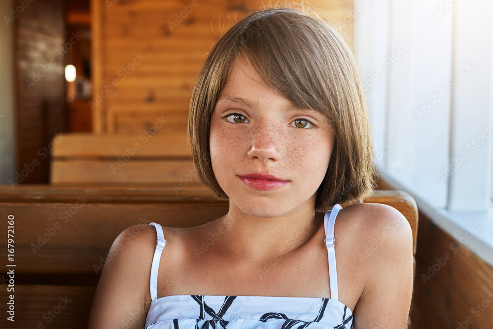 Children, rest, relaxation concept. Pleasant-looking freckled girl with ...