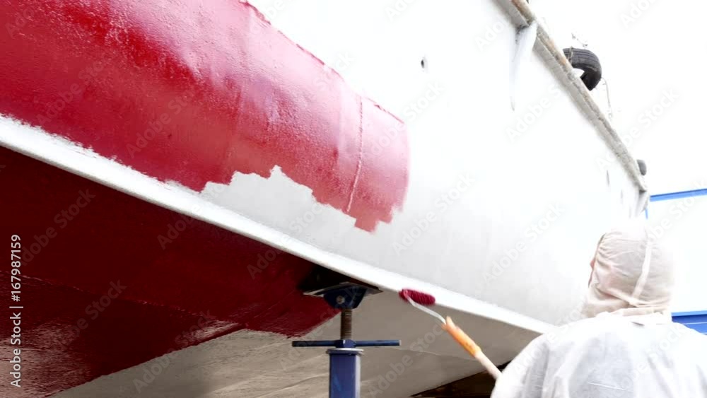 Worker paints red color metal of old rusty ship at shipyard in port of ...