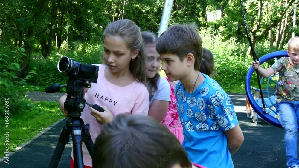 Children with video camera on tripod make movies about nature of green ...