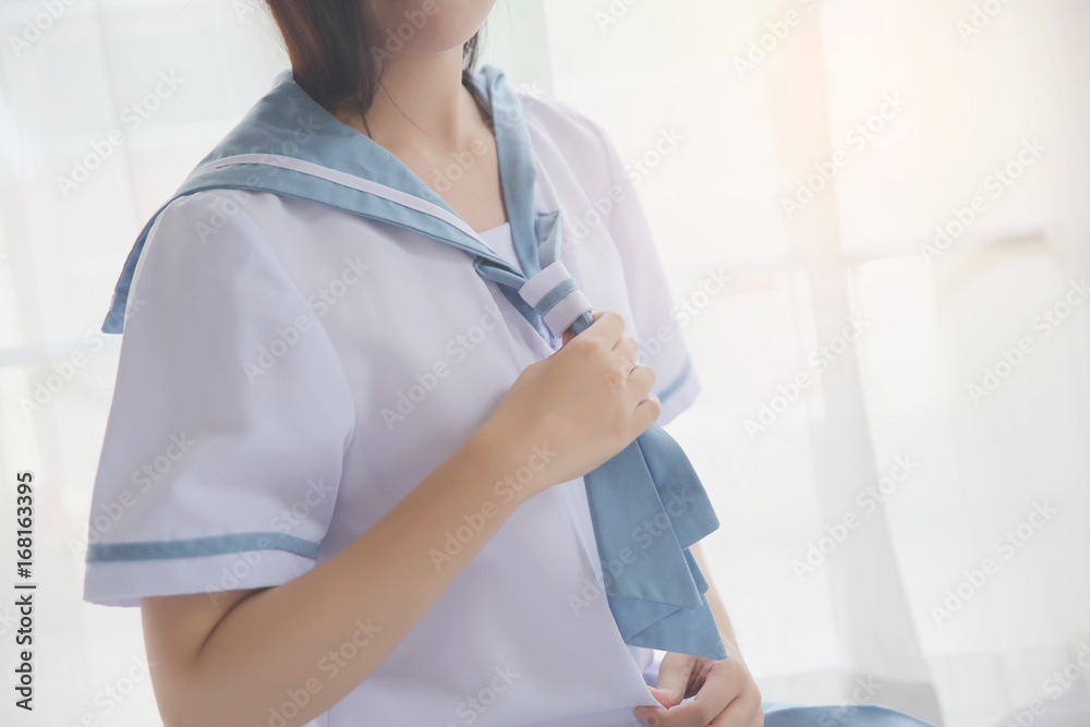 School girl getting dressed on white room Stock Photo | Adobe Stock