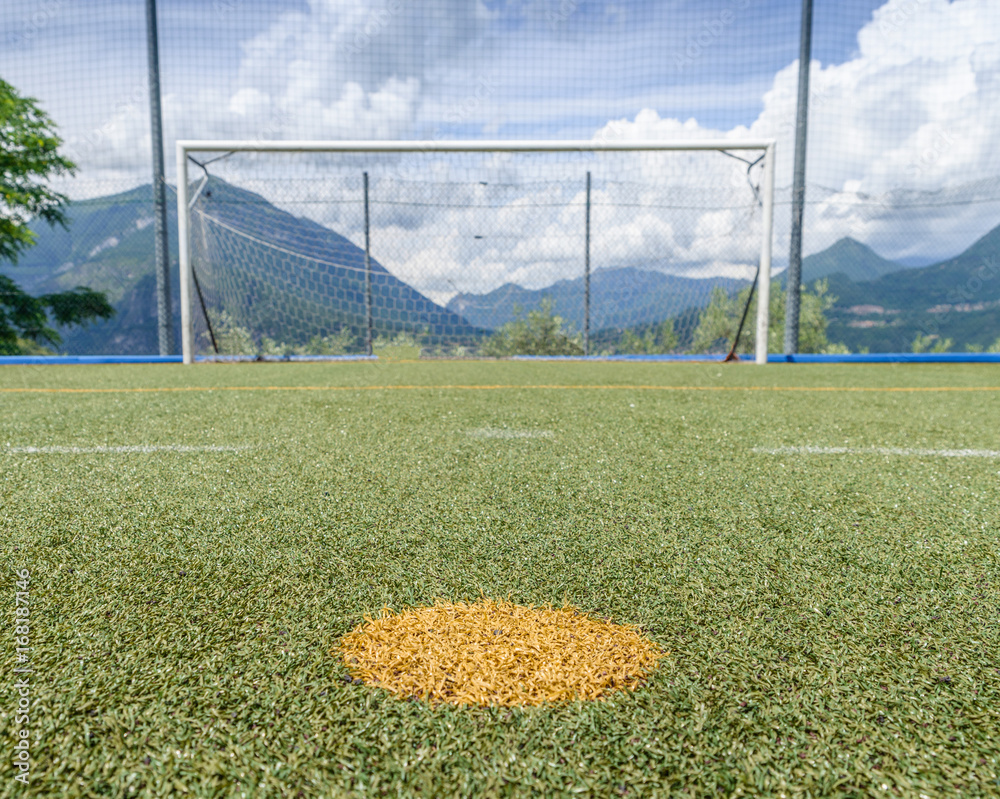 Selective focus on penalty spot with soccer / football goal on a ...
