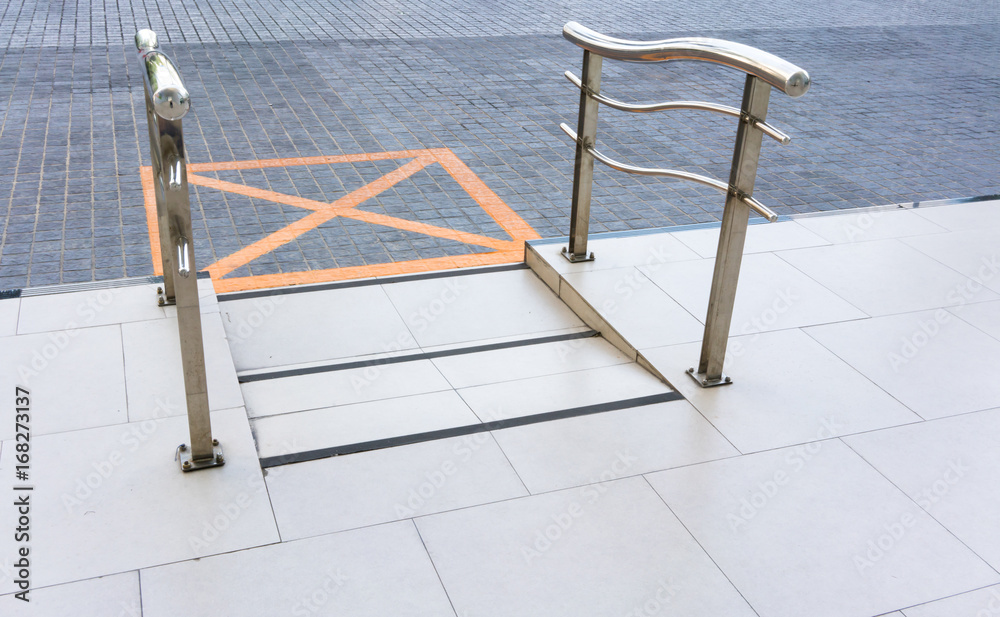 Ramped access, using wheelchair ramp with information sign on floor ...