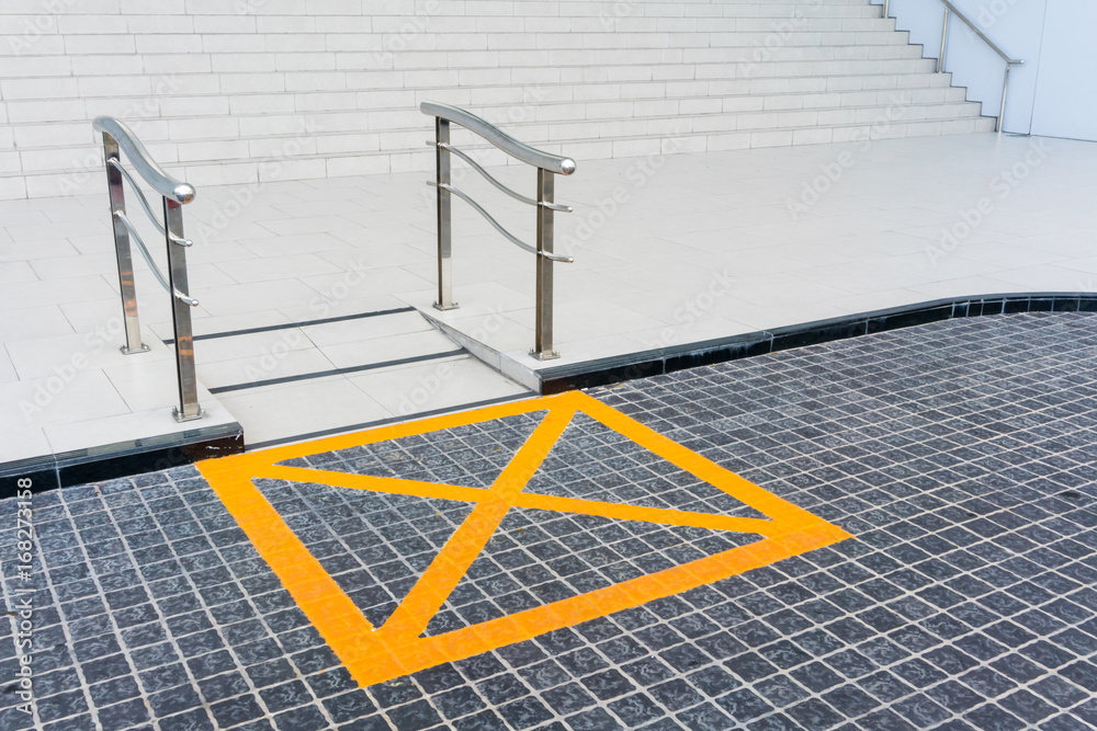 Ramped access, using wheelchair ramp with information sign on floor ...