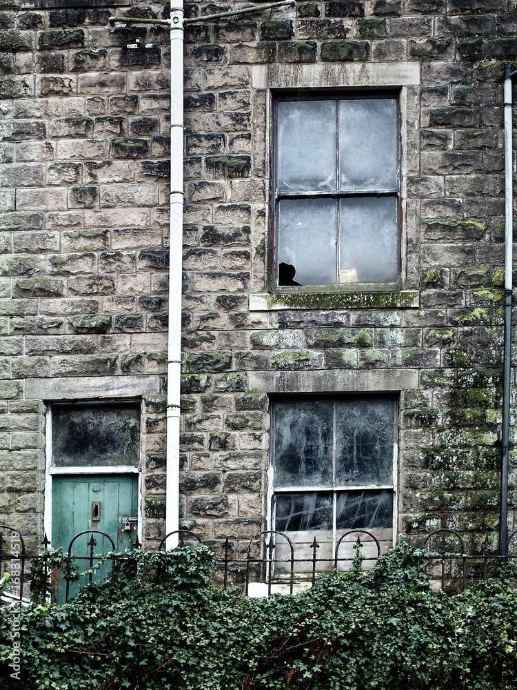 derelict abandoned house with broken windows and ivy growing up the ...