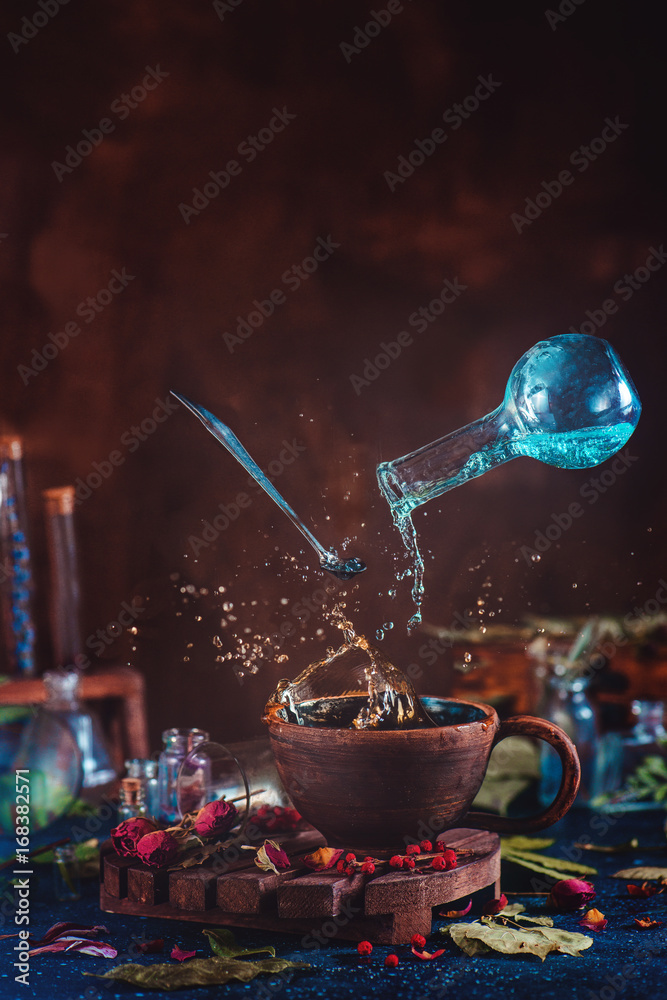 Flying potion bottle with pouring liquid in a magical still life ...