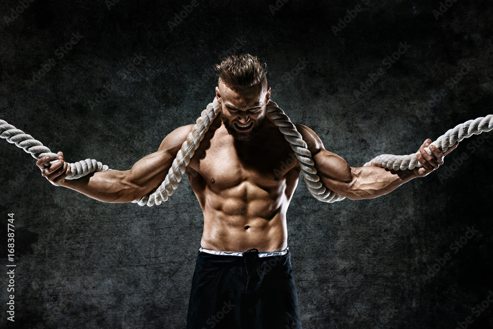 Muscular man with rope. Photo of man with perfect body after training ...