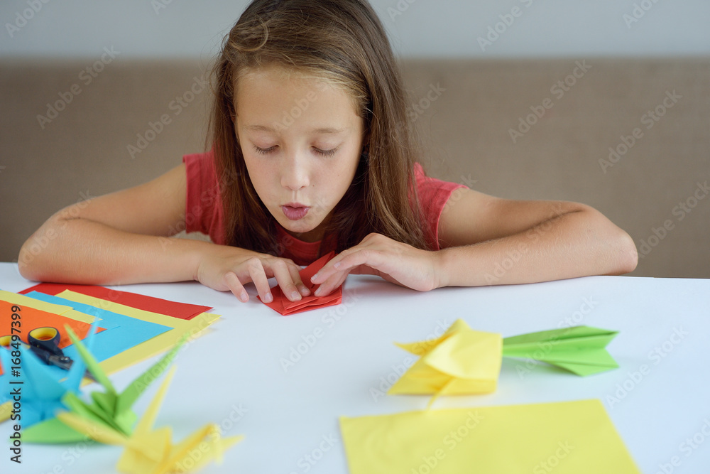 The girl puts origami from paper. lesson of origami Stock Photo | Adobe ...