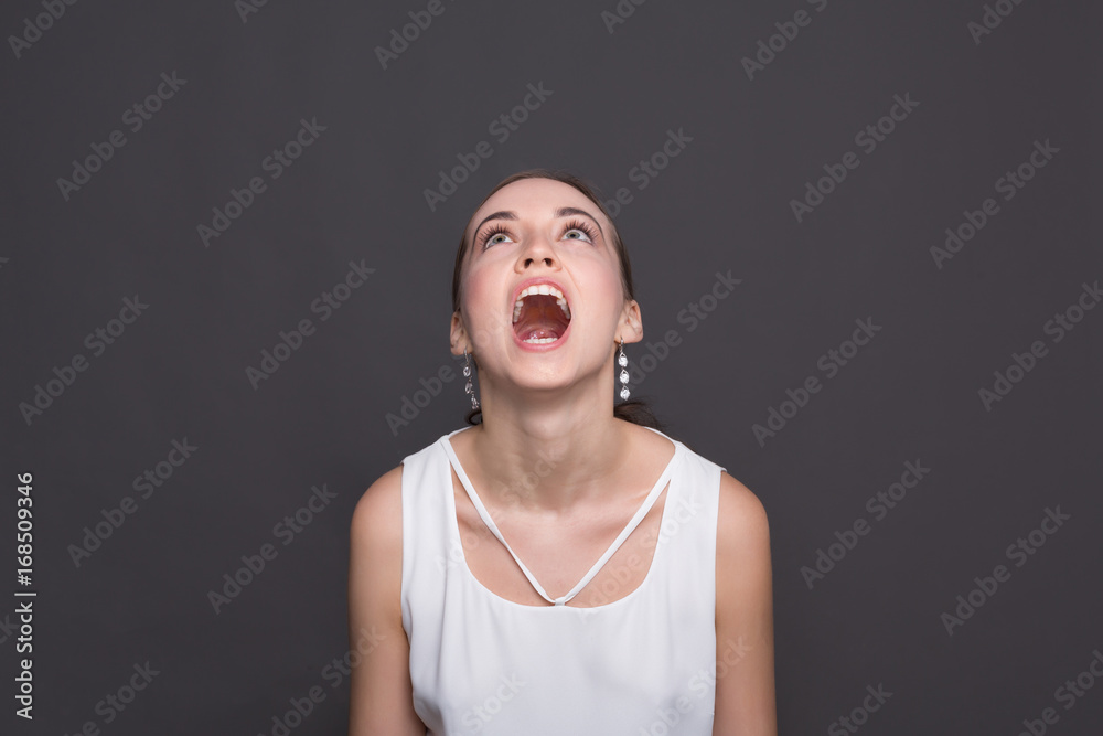 Screaming young woman looking up Stock Photo | Adobe Stock