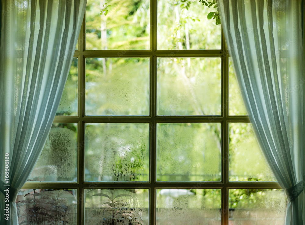 Foto de Glass window with condensation and curtains decoration in ...