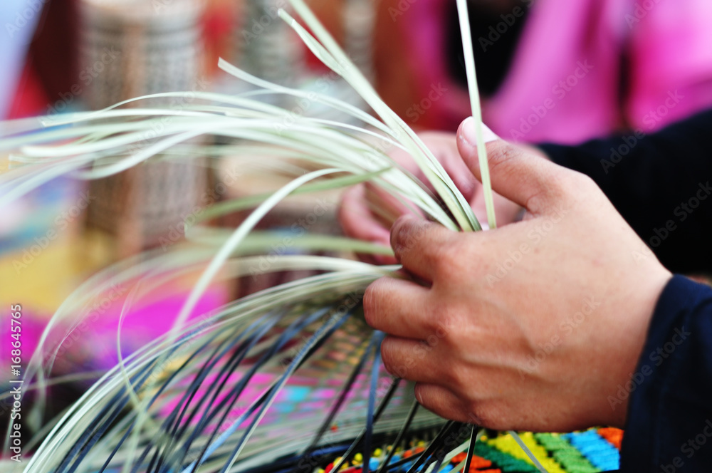 Hands of woman showing weaving action of traditional bamboo basket from ...