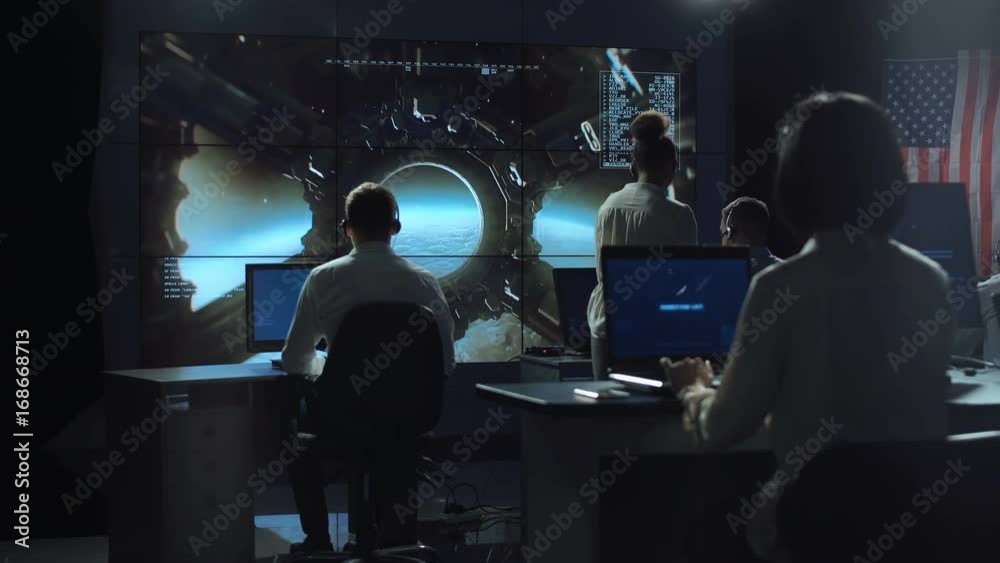 Vidéo Stock Back view of people working and managing space flight in mission control center ...