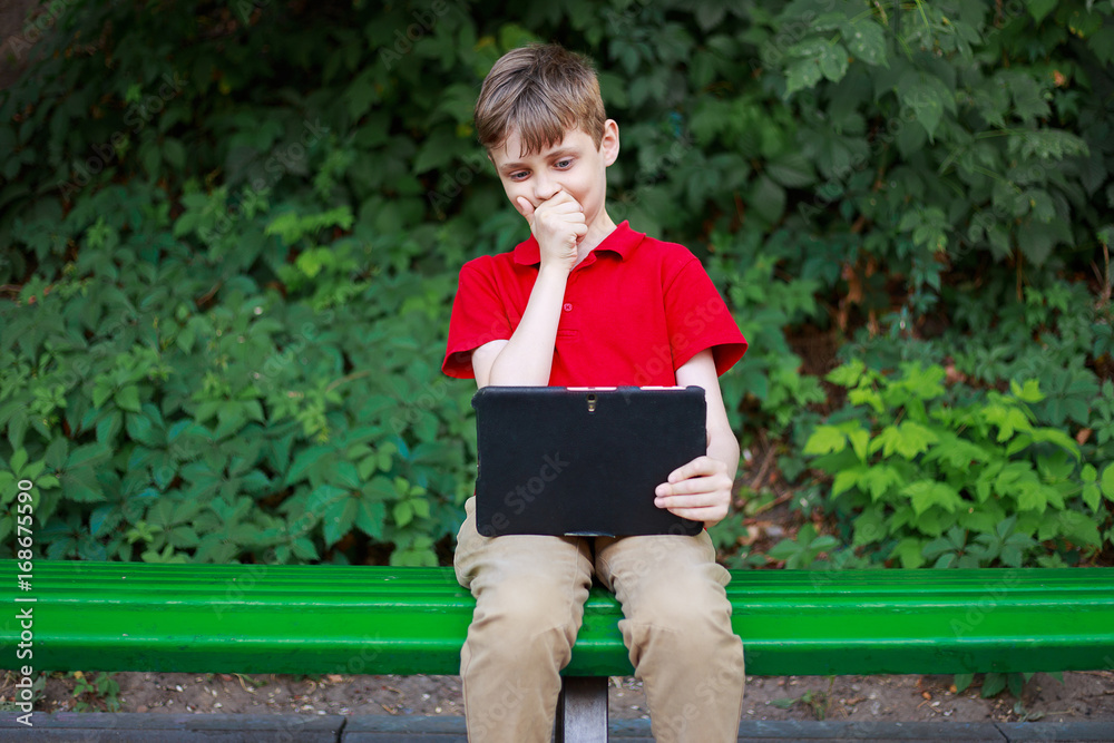Parental advisory, parental control. Shocked boy sitting with tablet in ...