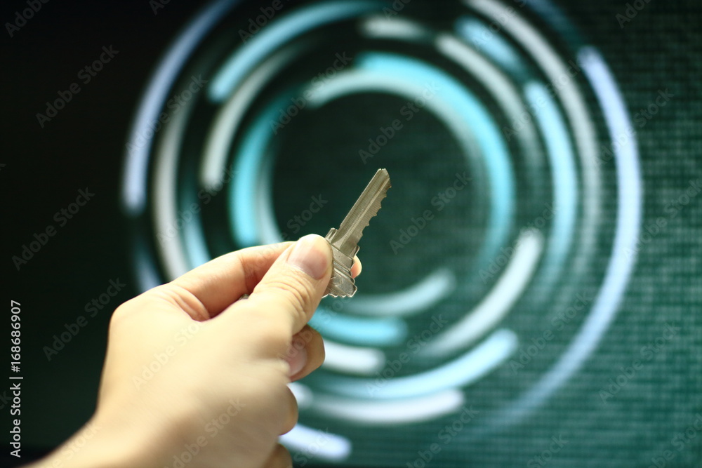 hand holding Key in front of a computer screen. key to power and ...