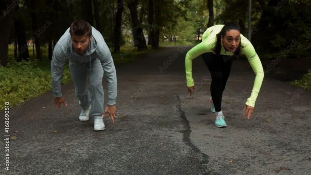 Vidéo Stock Fitness couple ready for running race on wooden walkway on ...