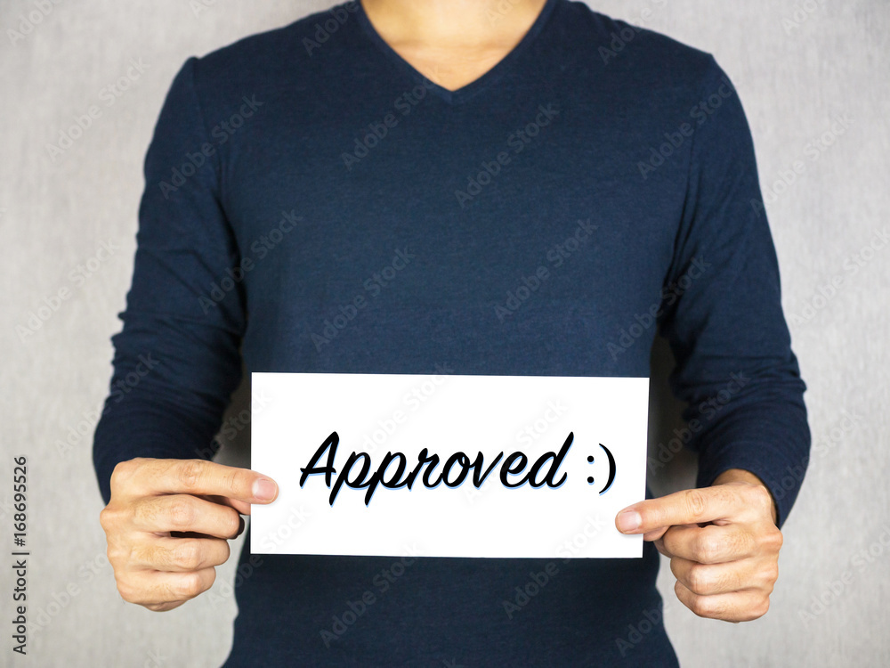 Approved text with smiley face icon, on white paper holding by man ...