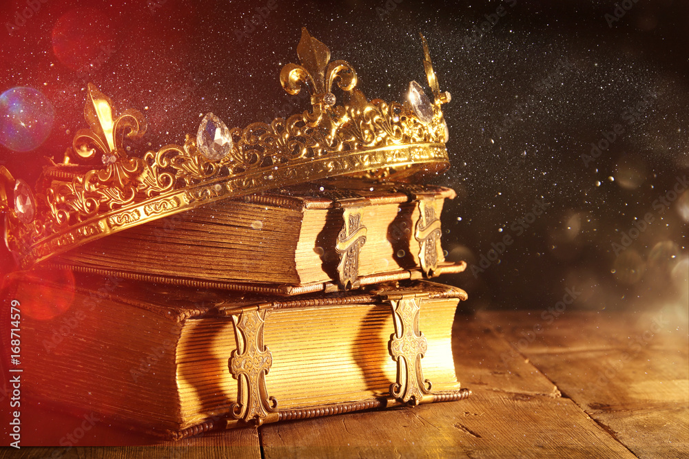 low key of beautiful queen/king crown on old books. vintage filtered ...