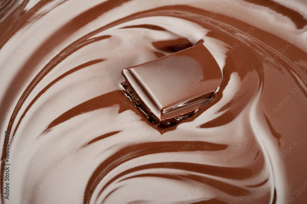 Melted piece of chocolate bar in glossy chocolate splash background ...