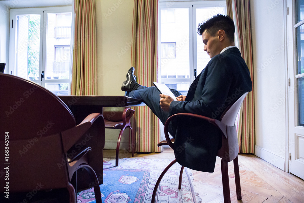 Side View Of Elegant Businessman Sitting On Chair Putting Legs On Table