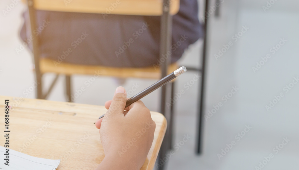 Blurred of Asian students hand holding pen for writing Exams paper ...