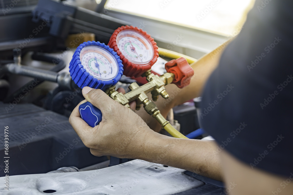 Auto mechanic uses a pressure gauge on the air compressor,liquid air ...