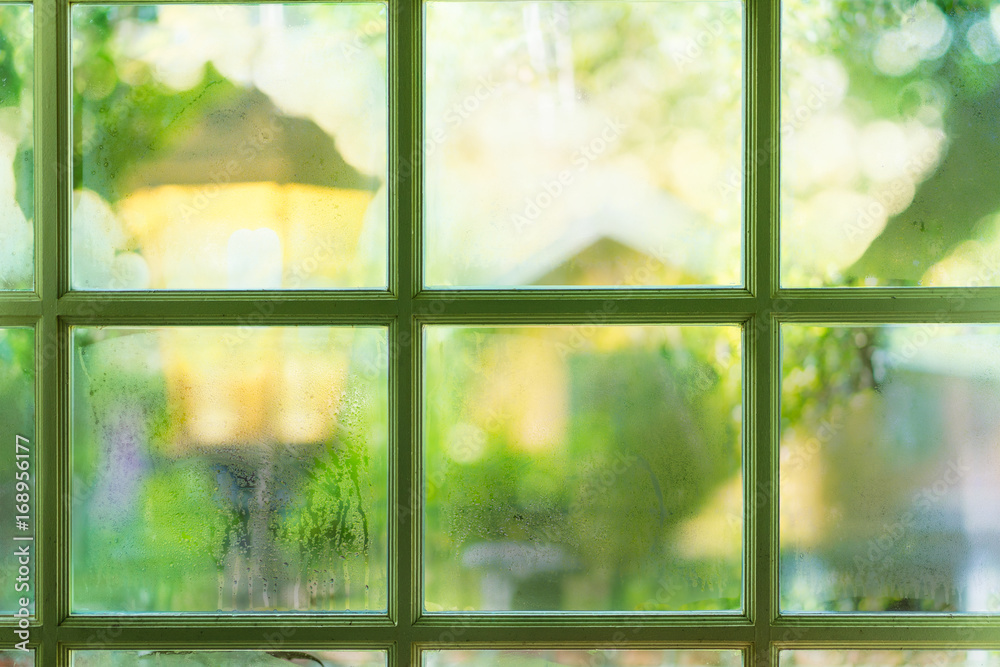Green window with condensation with blur home and lamp in the garden ...