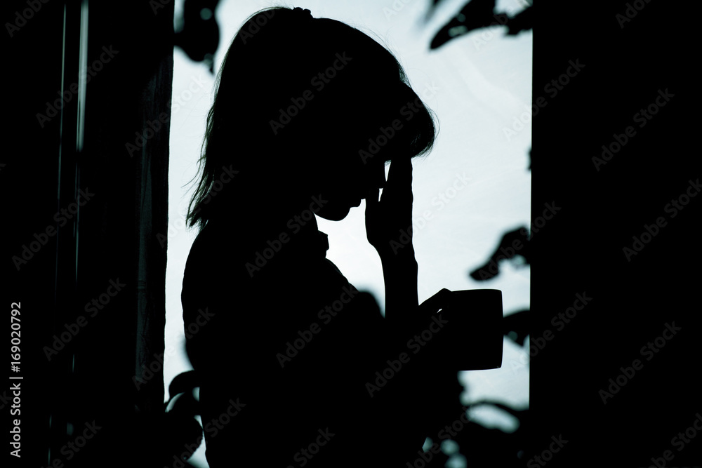 woman silhouette in depression, sad girl standing near window and ...