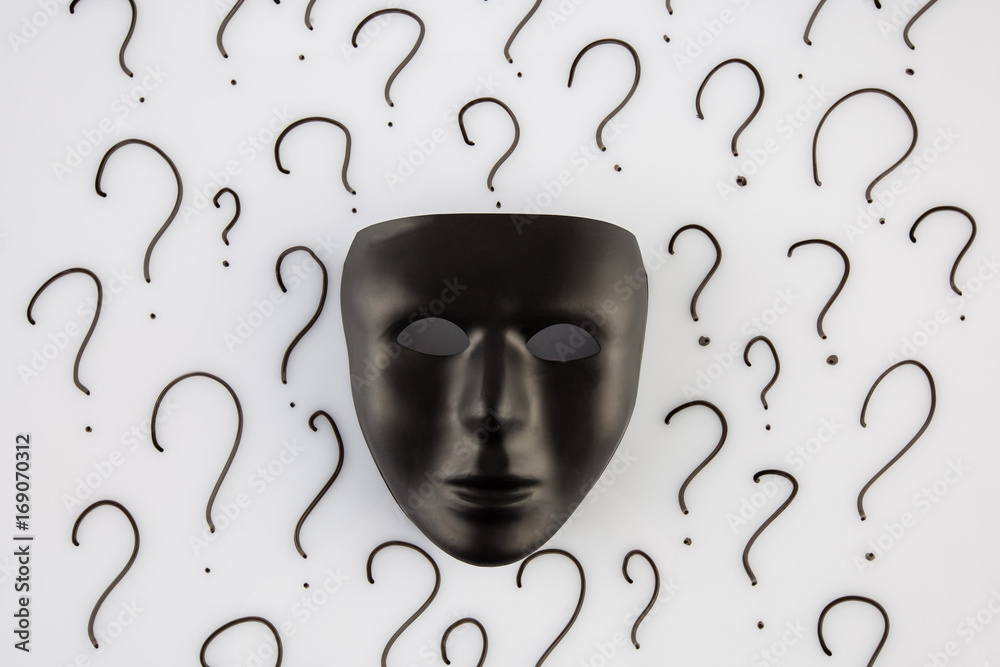 Black mask on white background with black question marks. Who am I ...