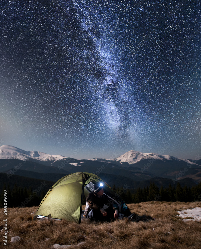 Male hiker have a rest in his camping in the mountains at night. Man ...